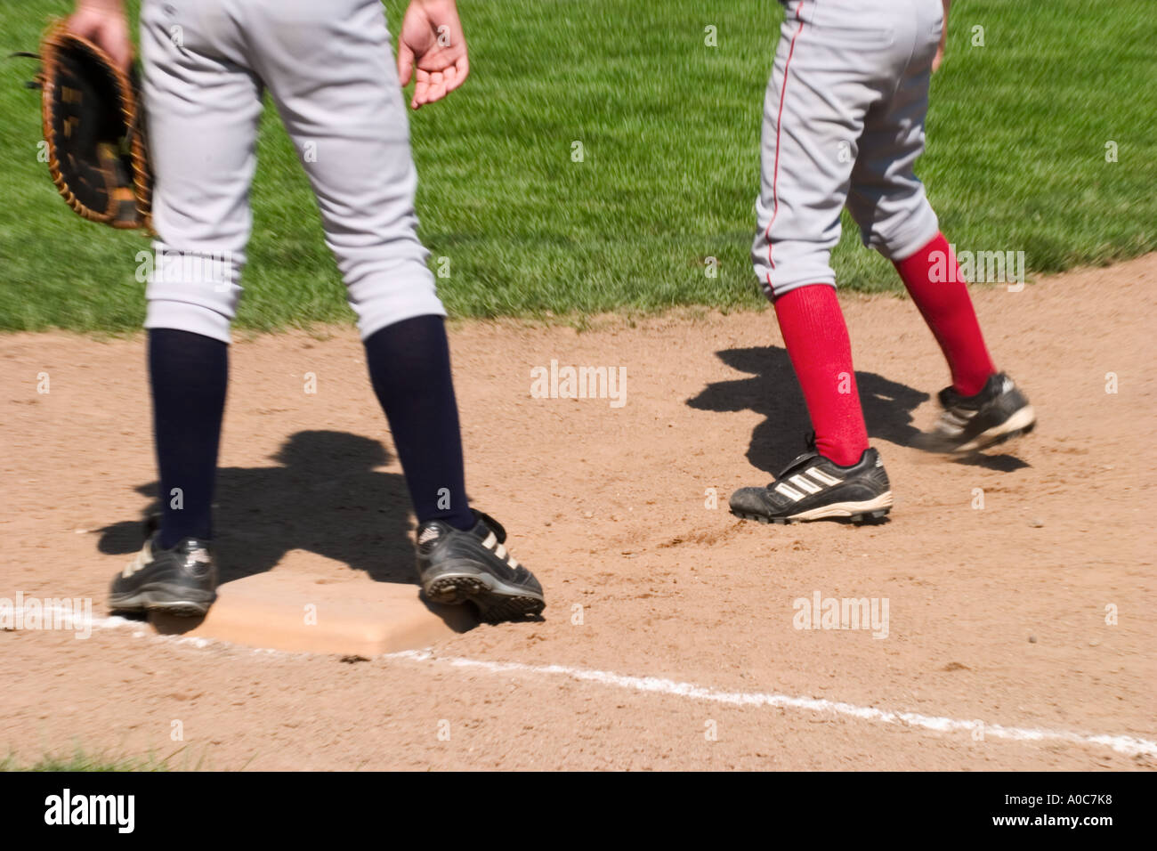 Preteen boy taking a lead off of first base with the boy playing first ...