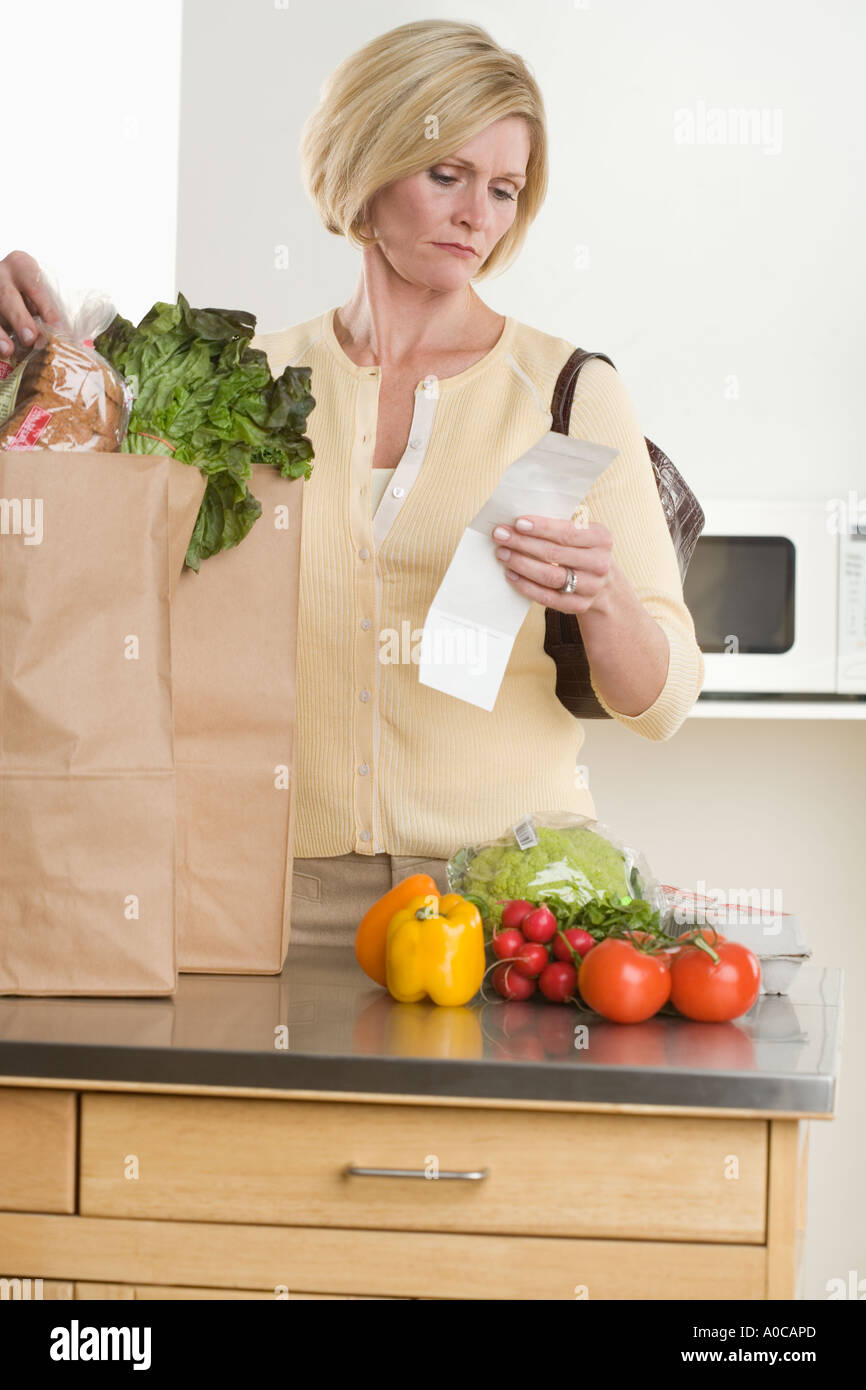 Woman checking grocery receipt Stock Photo - Alamy