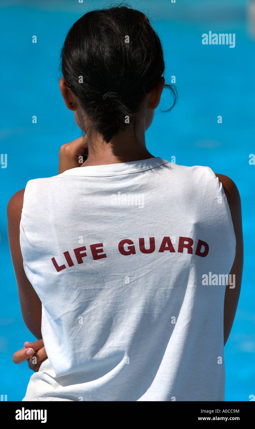 a lifeguard woman standing up watching the pool in water park waterpark ...