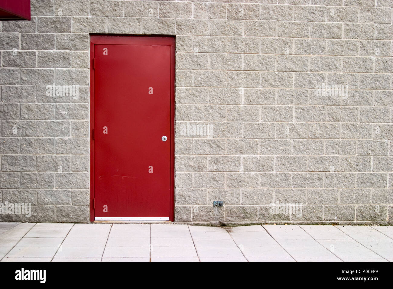 Red door on a cinder block building Stock Photo - Alamy