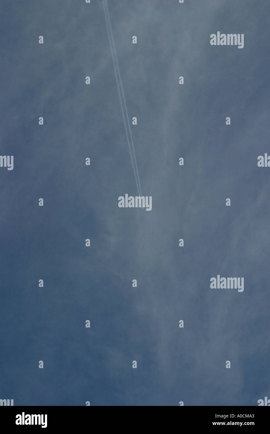 blue sky with wispy clouds and double smoke trail from a passing jet ...