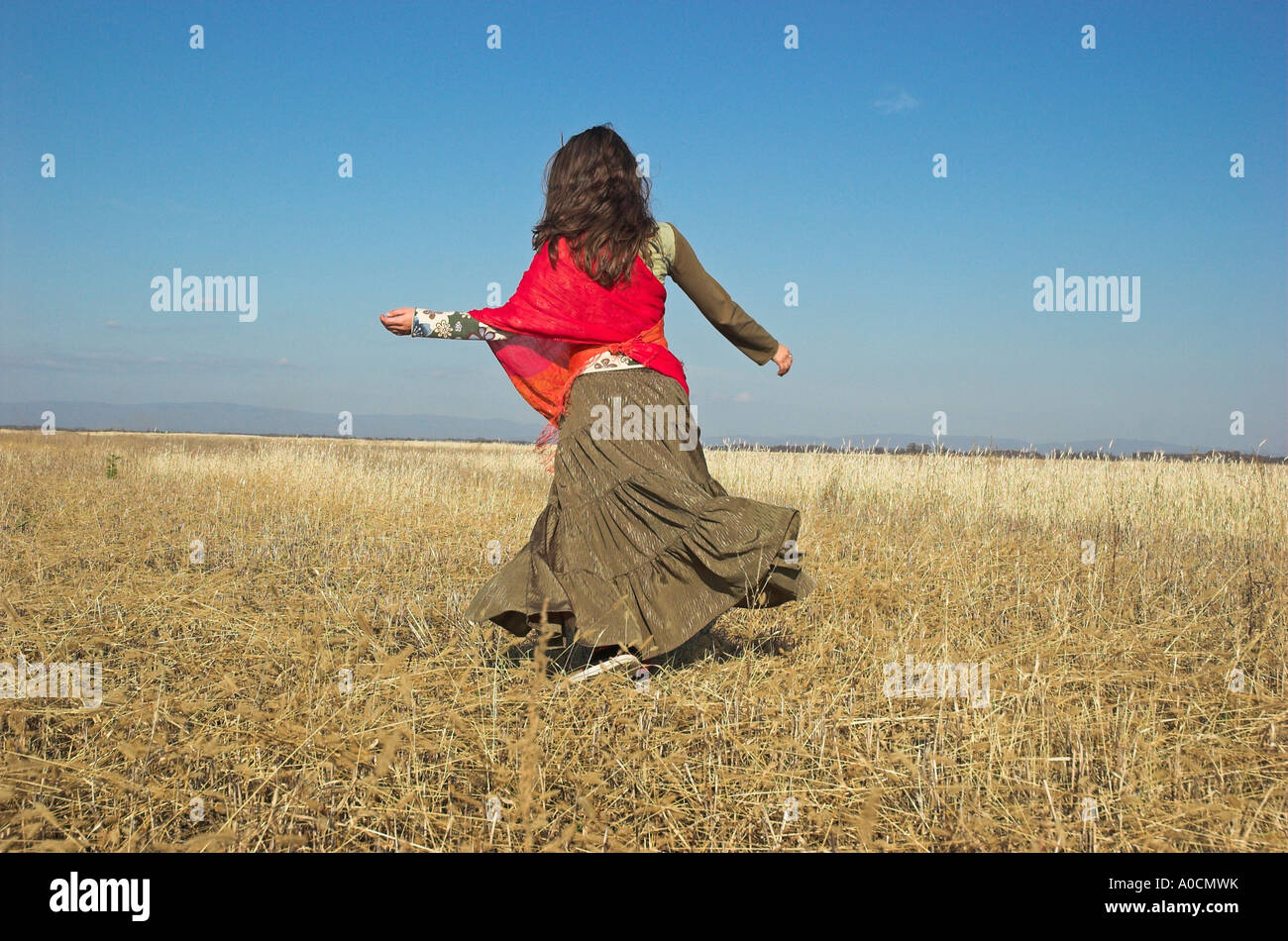 Young woman twirling in field Stock Photo - Alamy