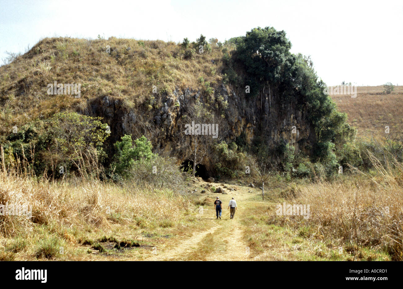 Two tourists walk towards a cave that was once a Pathet Lao refuge on ...