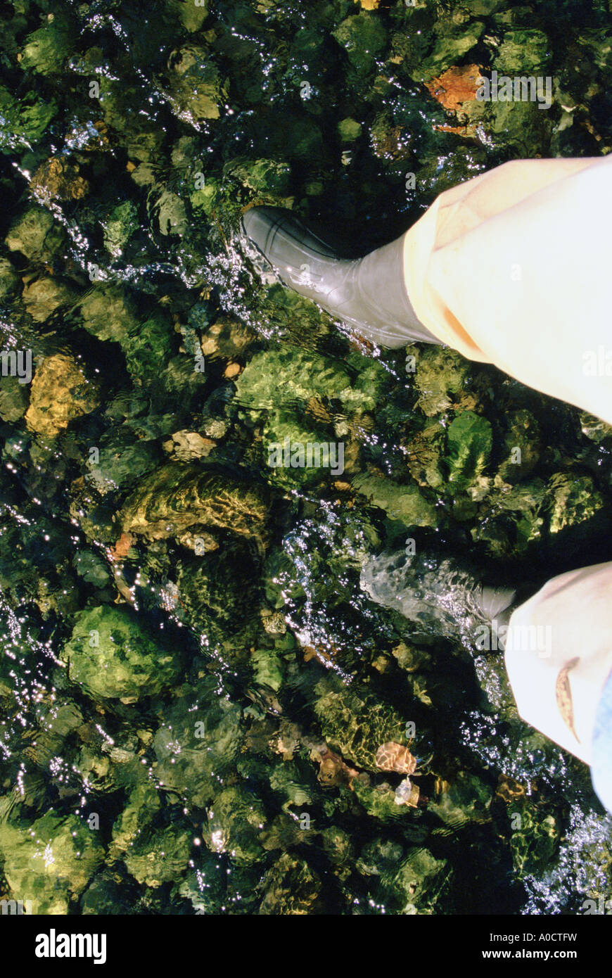 View from above of fishermans waders in shallow river filled with ...