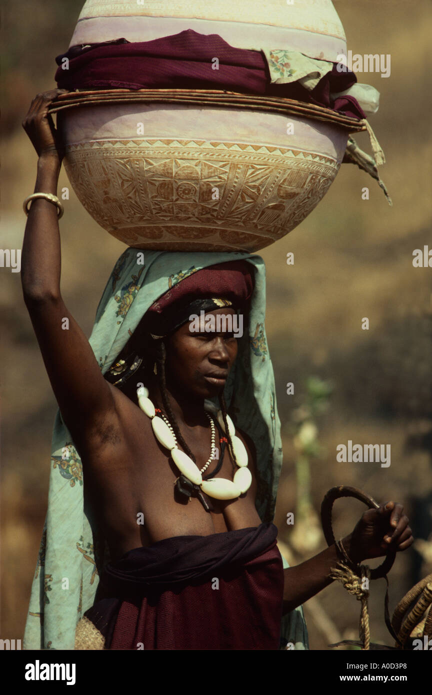 Fulani Woman wears white agate bead necklace carries carved calabash on ...
