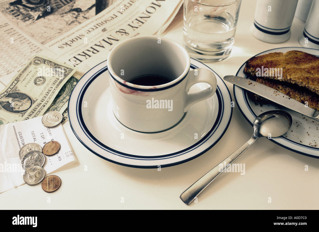 Coffee cup at diner table with newspaper and check Stock Photo - Alamy