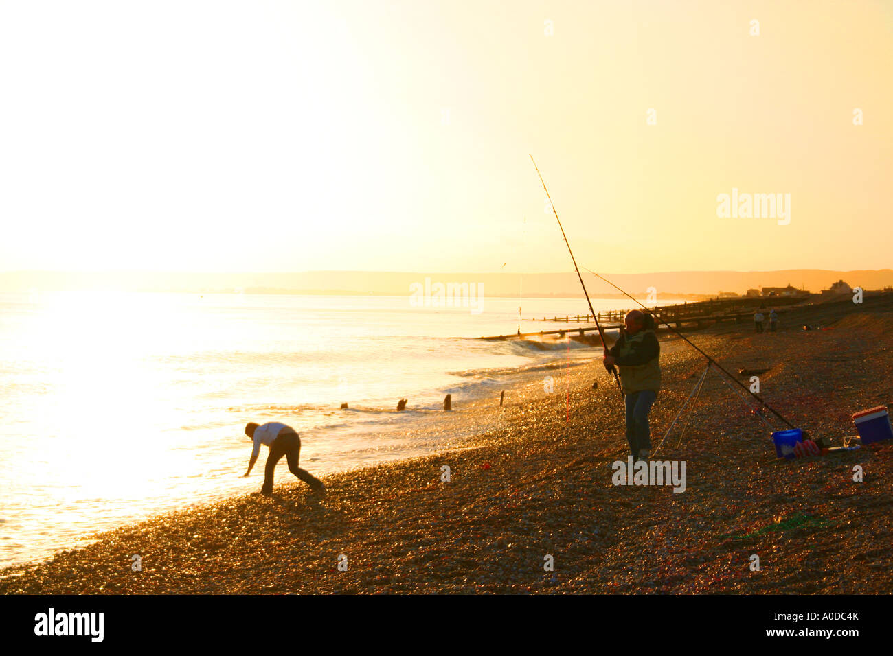 Fishing on the beach at sunset Stock Photo - Alamy