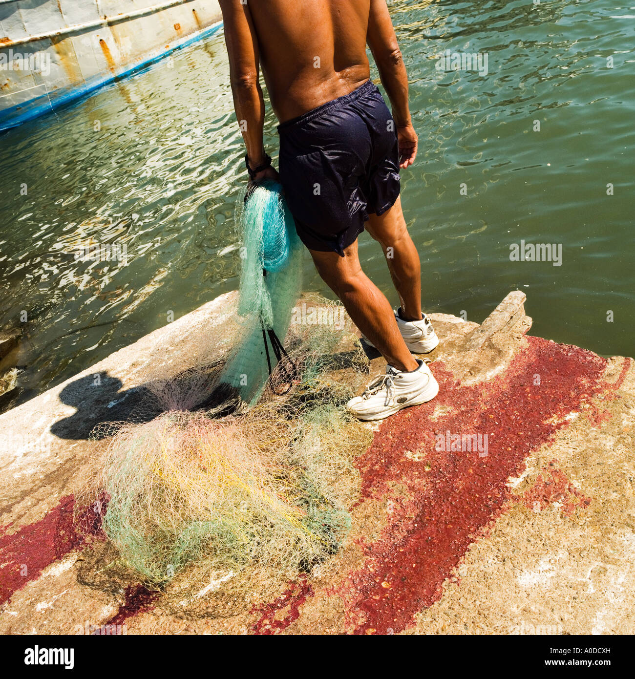 Fisherman with net on the quay Mexico No model release required: back ...