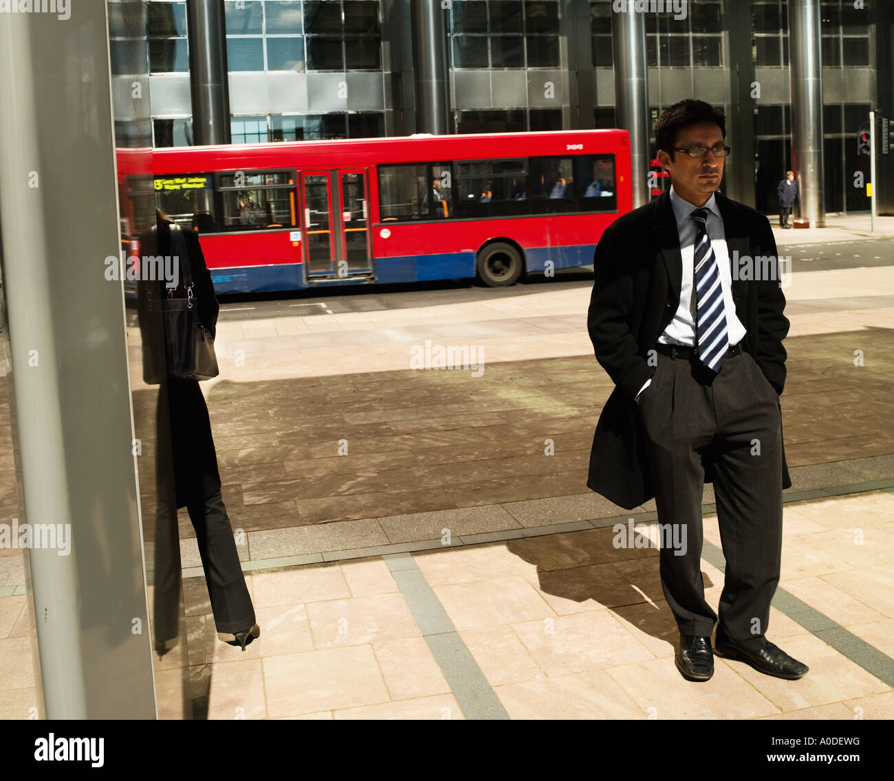 Business man at Canary Wharf with red bus behind. London England UK ...