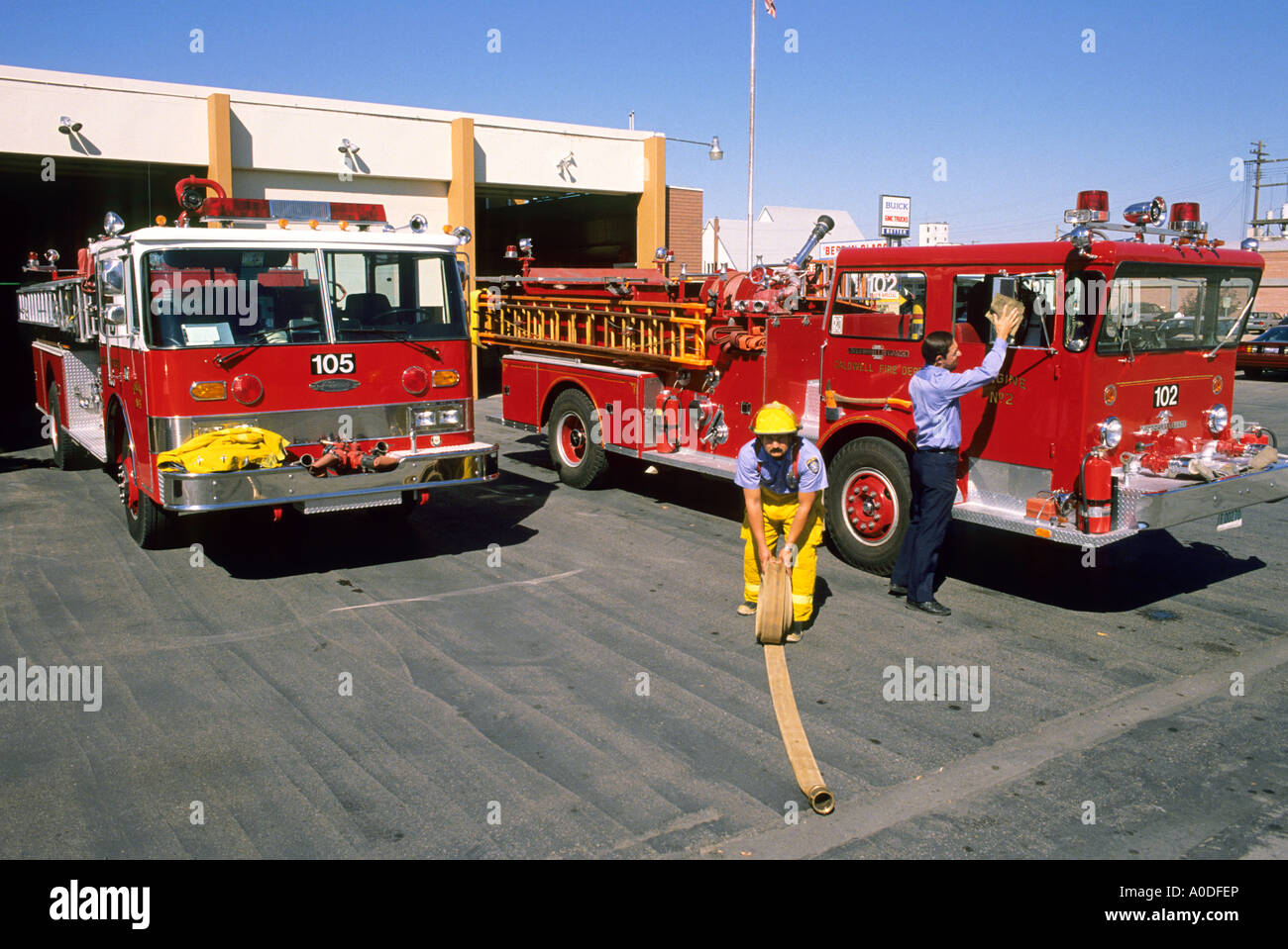 Firemen doing maintenance on fire trucks at a fire station in Caldwell ...
