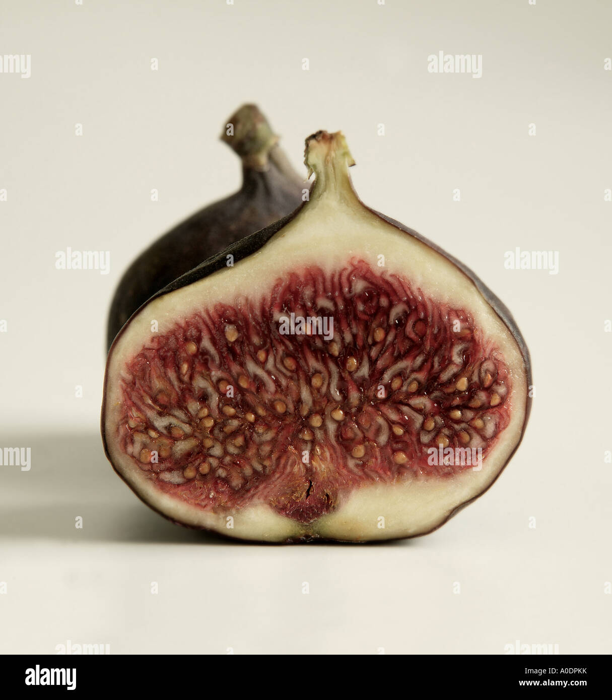 flat soft lighting on two figs on studio white background with one ...