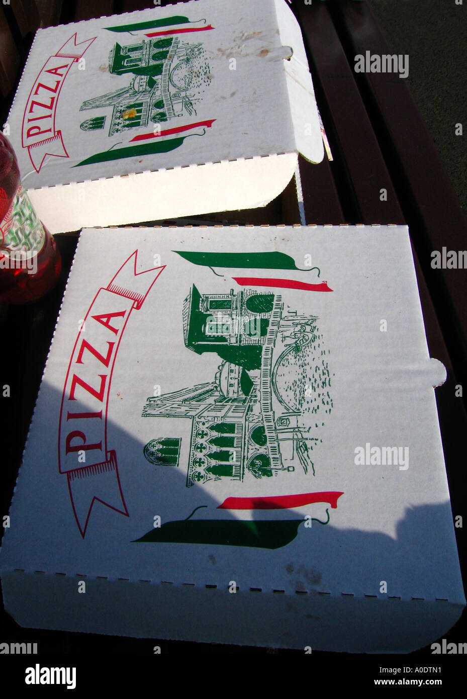 Discarded empty take away pizza boxes on park bench Stock Photo - Alamy