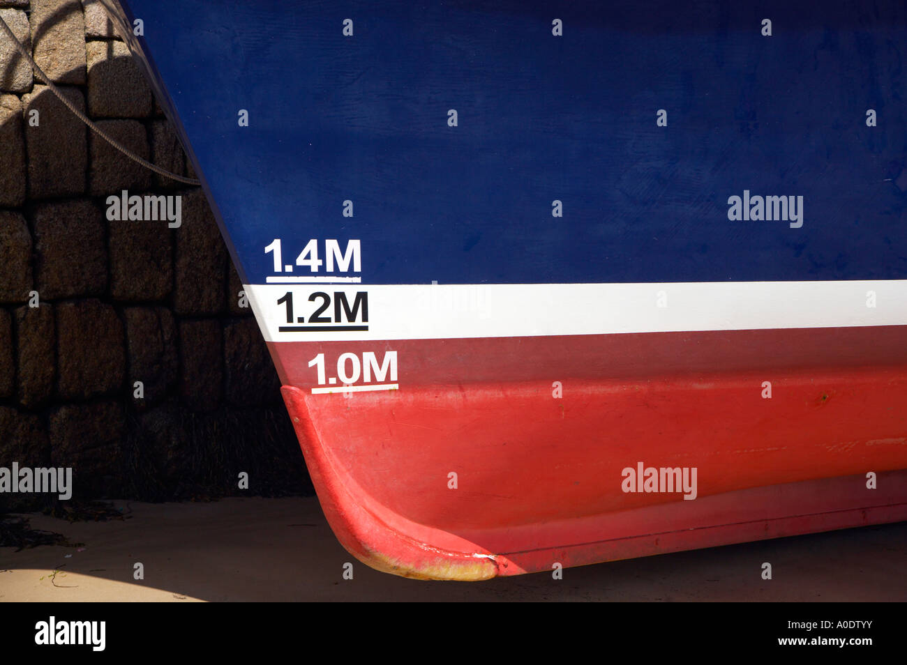 Boat pulled onto beach showing depth markers on hull Stock Photo - Alamy