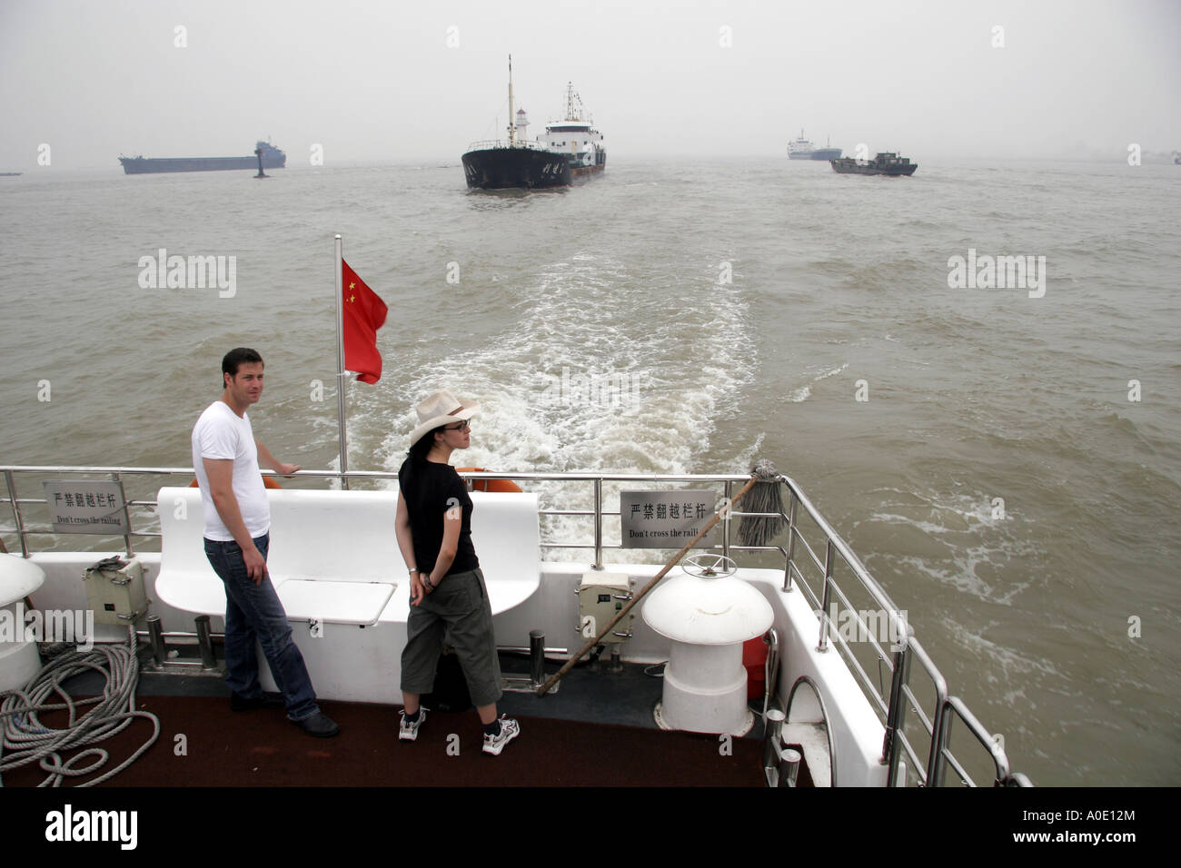Western tourists on a tour boat, travelling up to the mouth of the ...