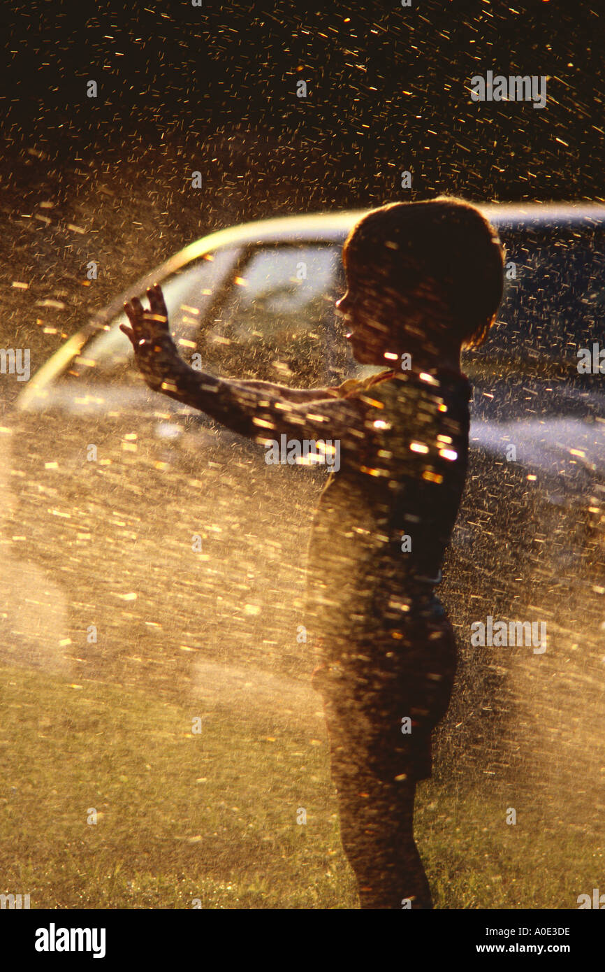Child sprayed by sprinkler Stock Photo - Alamy