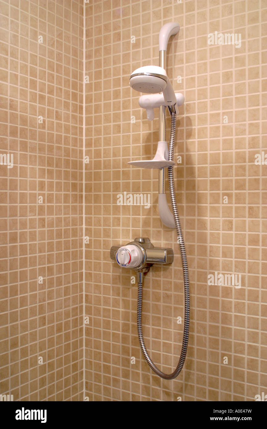 Shower head and taps on a wall of small sized tiles Stock Photo - Alamy