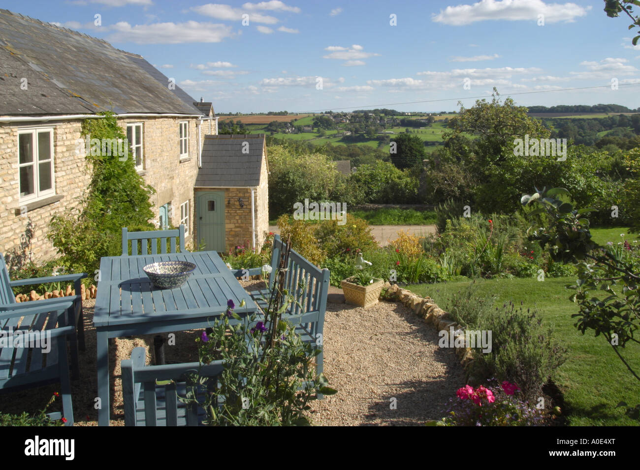 UK garden patio terrace with table and chairs and a view over open ...