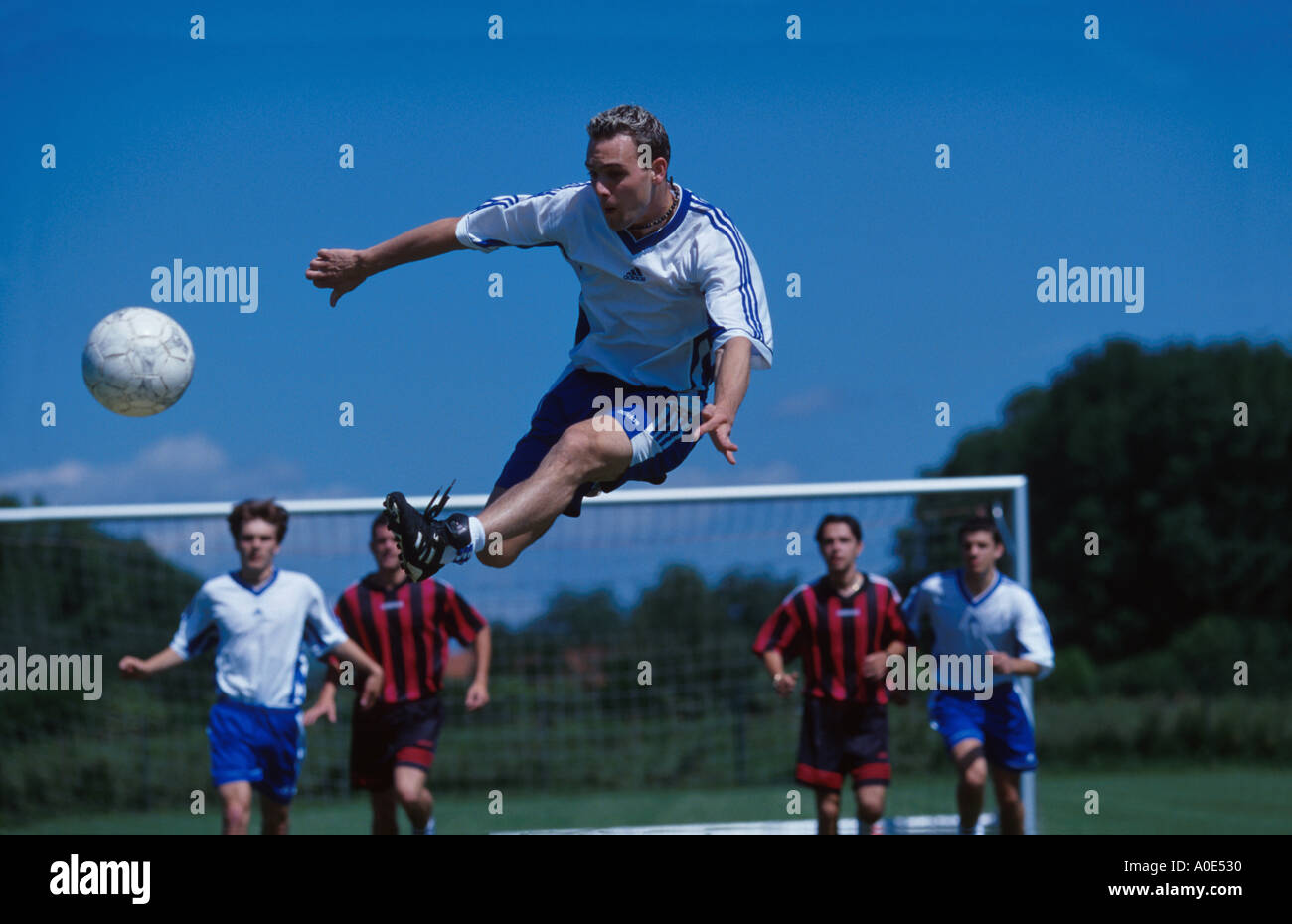 soccer football player striking ball by jumping Stock Photo - Alamy