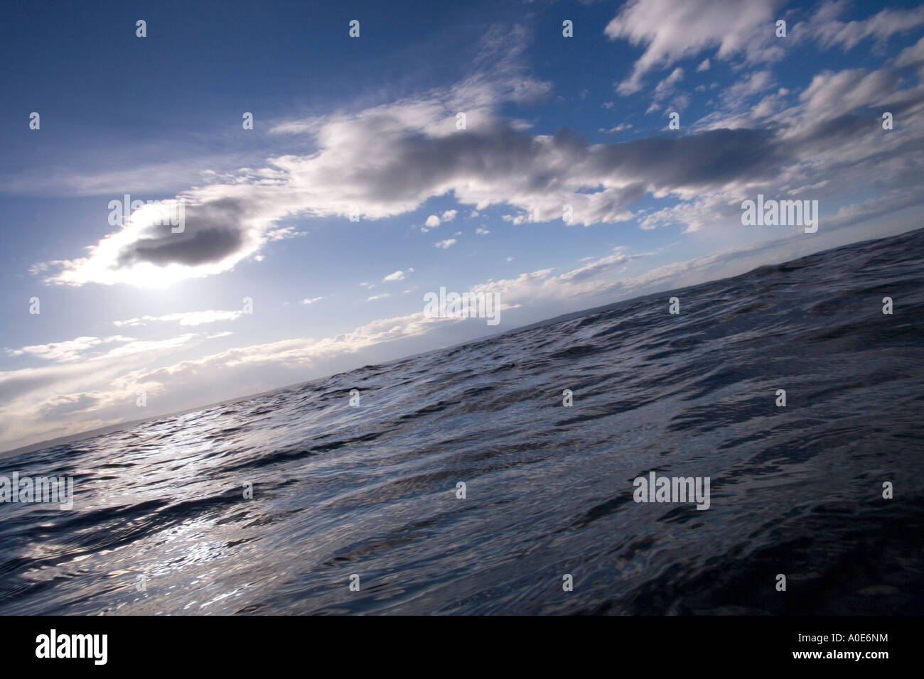 Water level abstract view of ocean and backlit clouds Stock Photo - Alamy