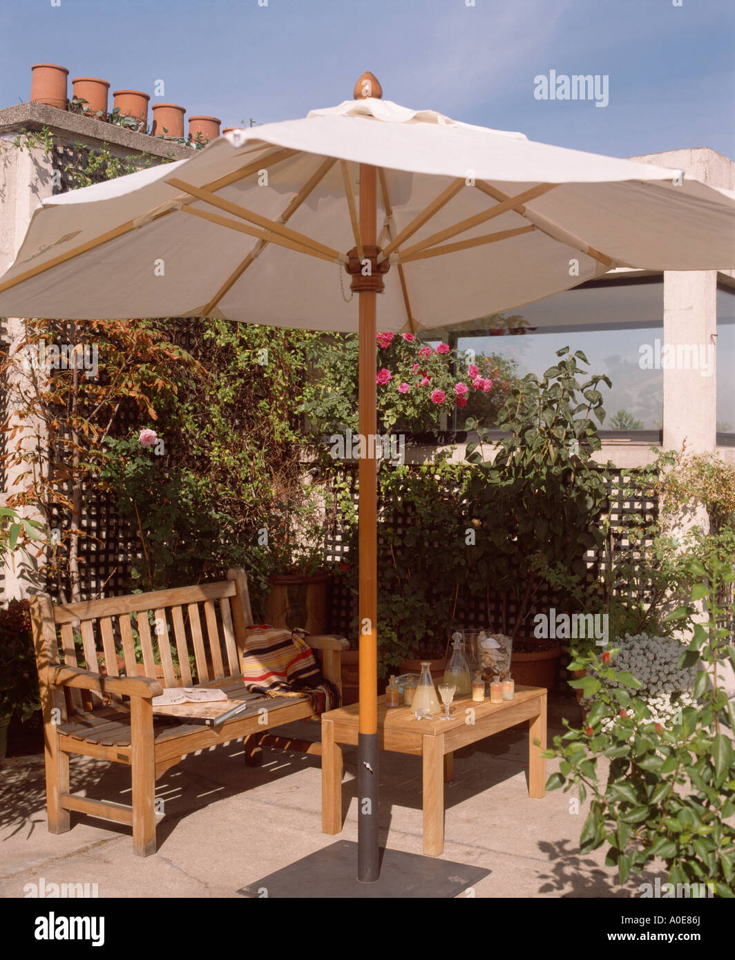 White parasol and wooden bench and chair on roof terrace in France ...