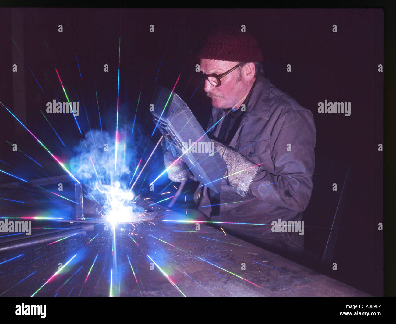 Man using electric welding equipment shot with flash fill on the face ...
