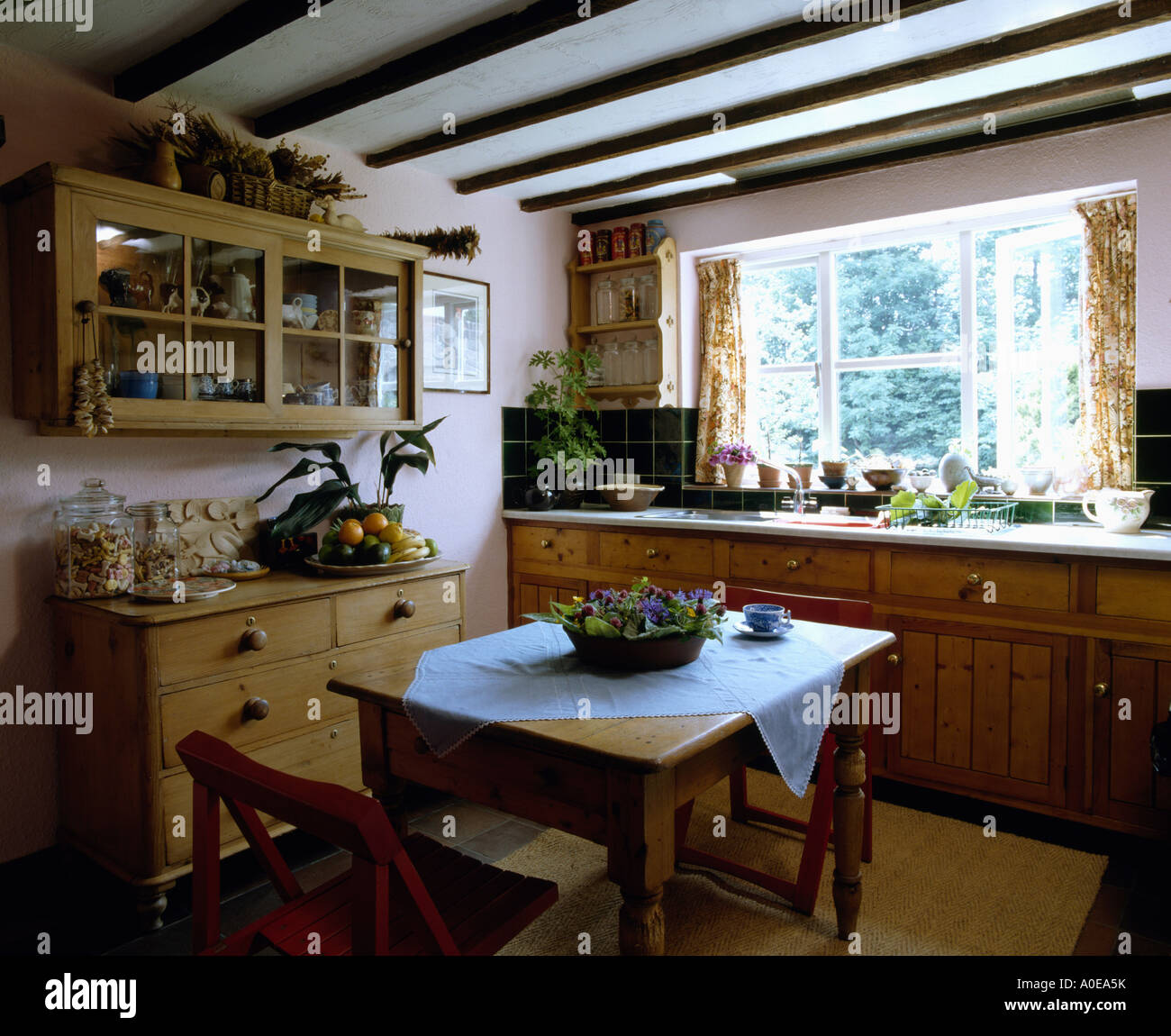 Pine table in cottage kitchen with view through window Stock Photo - Alamy