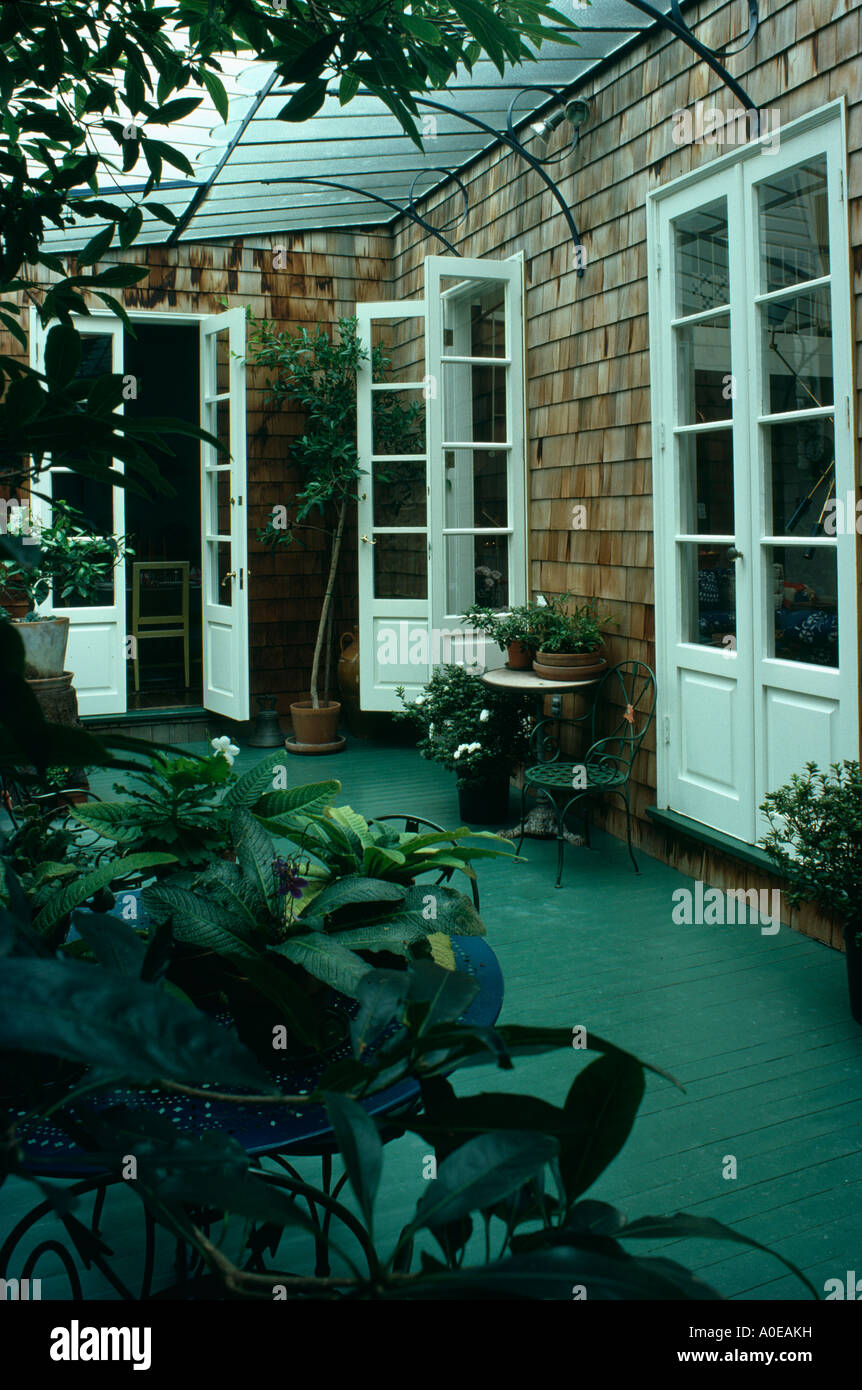 Brick conservatory extension with doors and green floor Stock Photo - Alamy