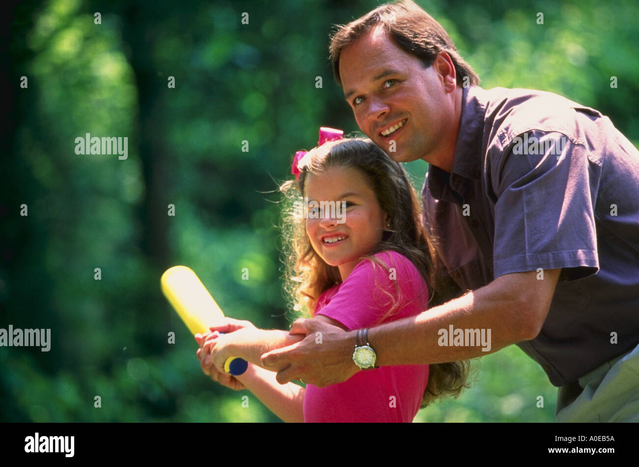 Father shows daughter how to swing a baseball bat Stock Photo - Alamy