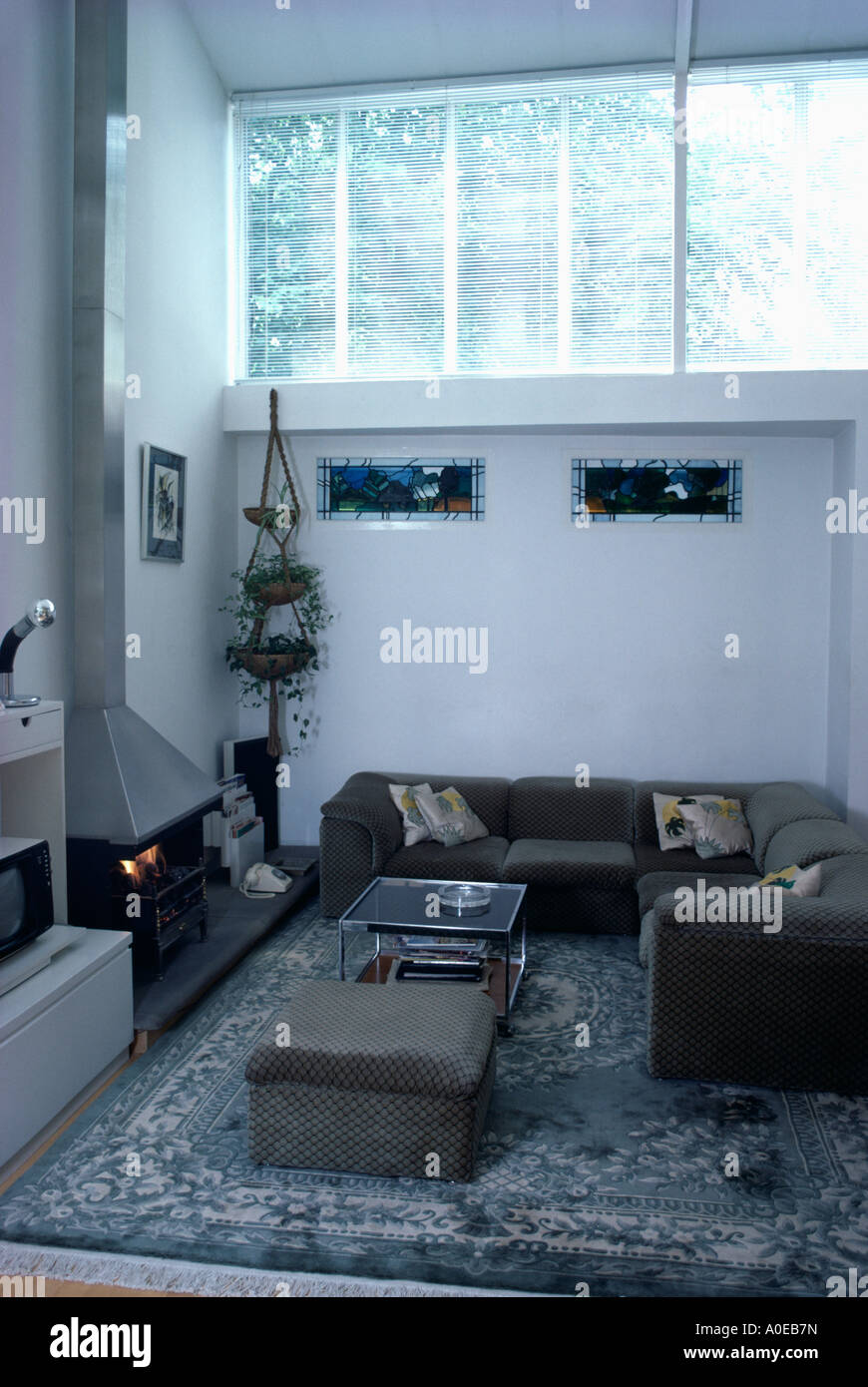 High window above sofa with fireplace in white livingroom Stock Photo ...