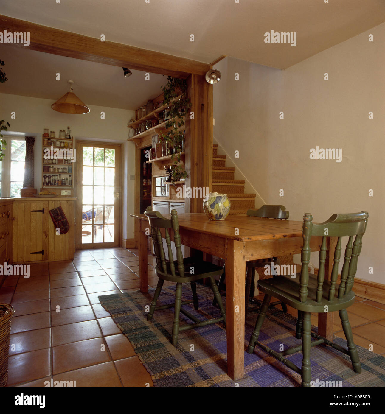 Wooden table and chairs on tiled floor Stock Photo - Alamy
