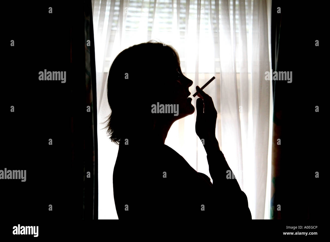 Woman smoking by window hi-res stock photography and images - Alamy