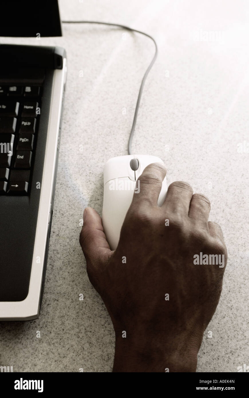 Closeup of mans hand on mouse with laptop computer Stock Photo - Alamy