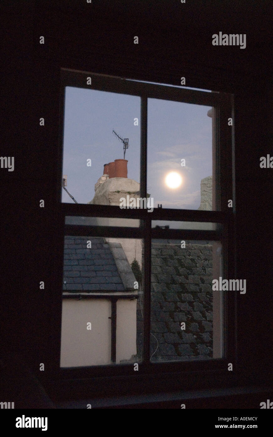 Full moon through window with chimney pots Stock Photo - Alamy