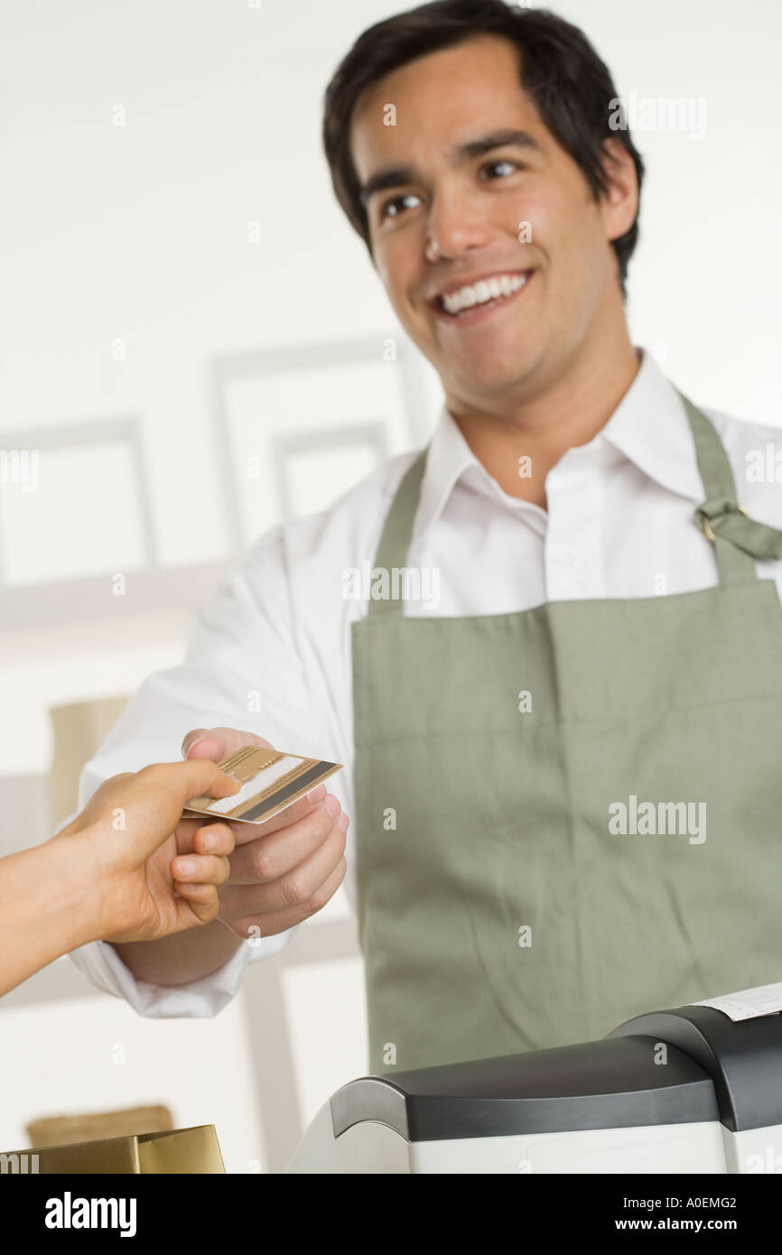Shopkeeper taking credit card Stock Photo - Alamy