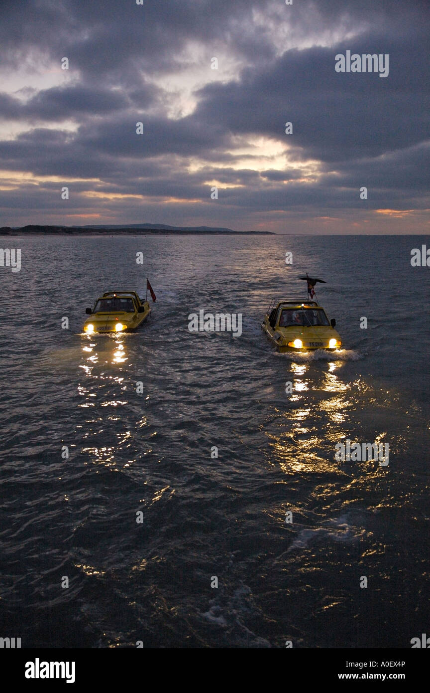 Two Dutton Commander amphibious cars with headlights on crossing the ...