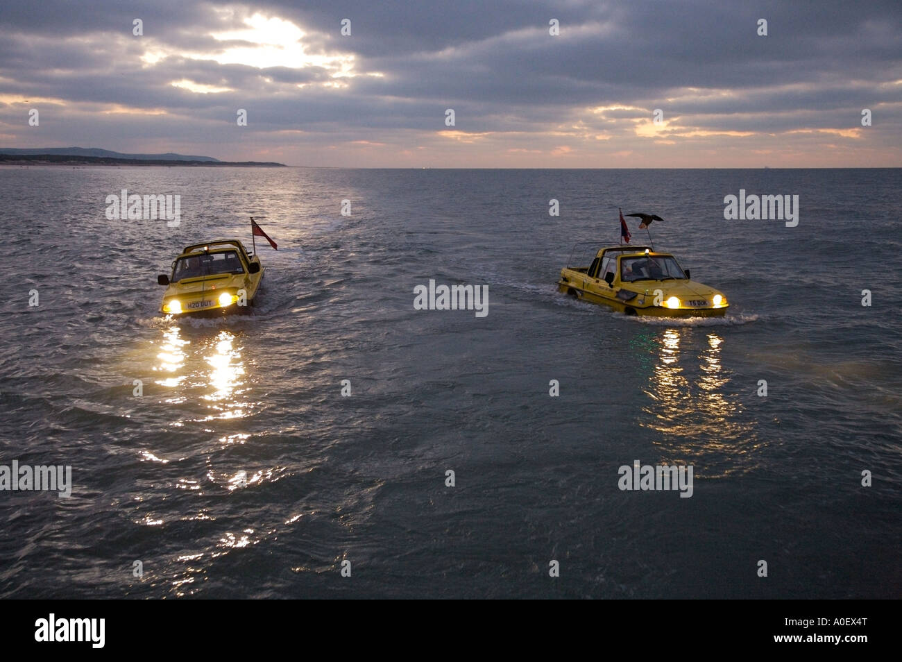 Two Dutton Commander amphibious cars with headlights on crossing the ...