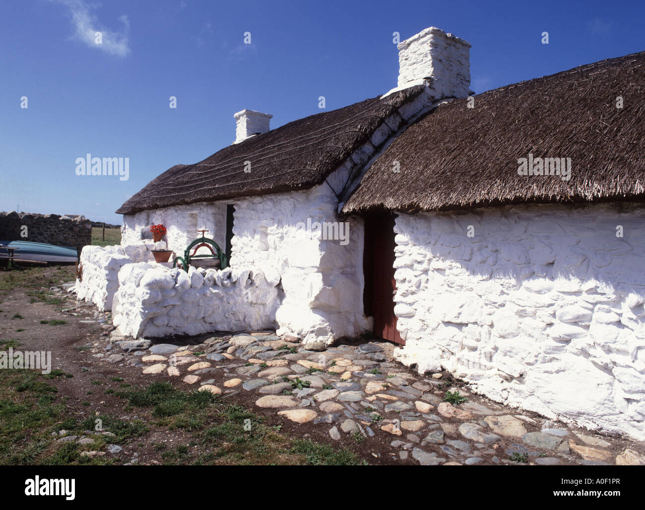 An old thatched stone cottage with its white wall now part of a museum ...