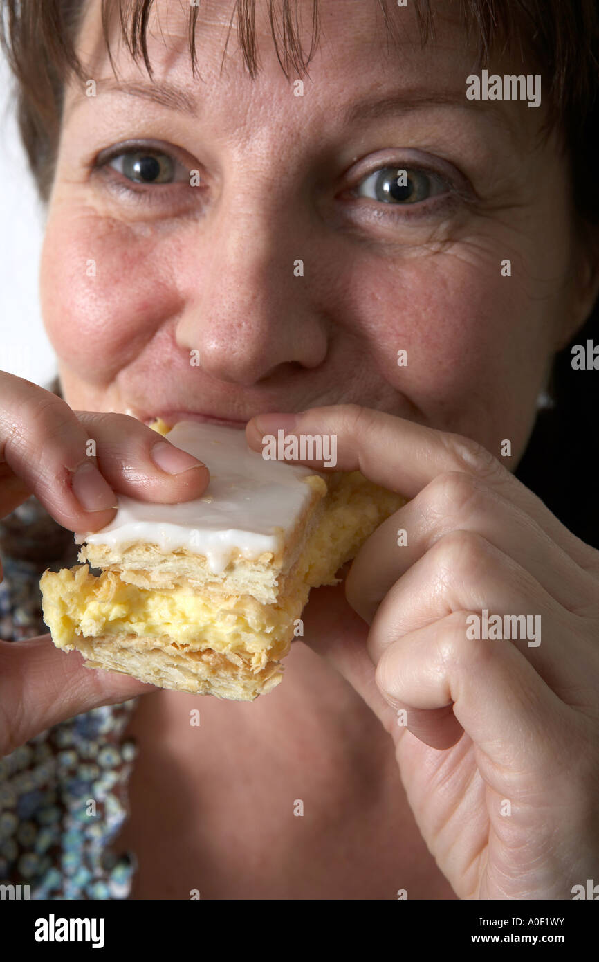 Woman eating a custard slice Stock Photo - Alamy
