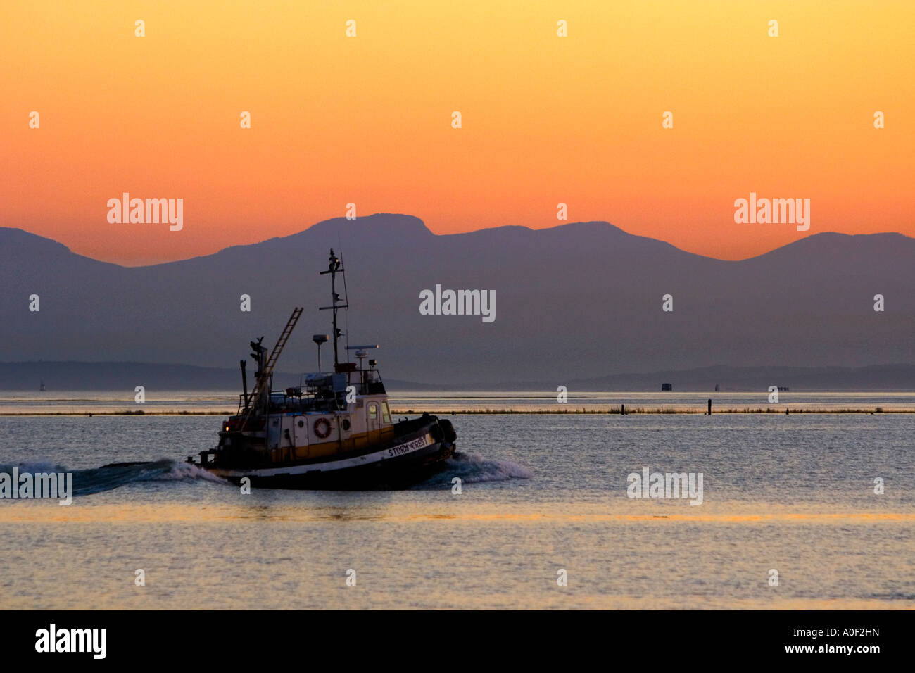 Tugboat under sunset sky Stock Photo - Alamy