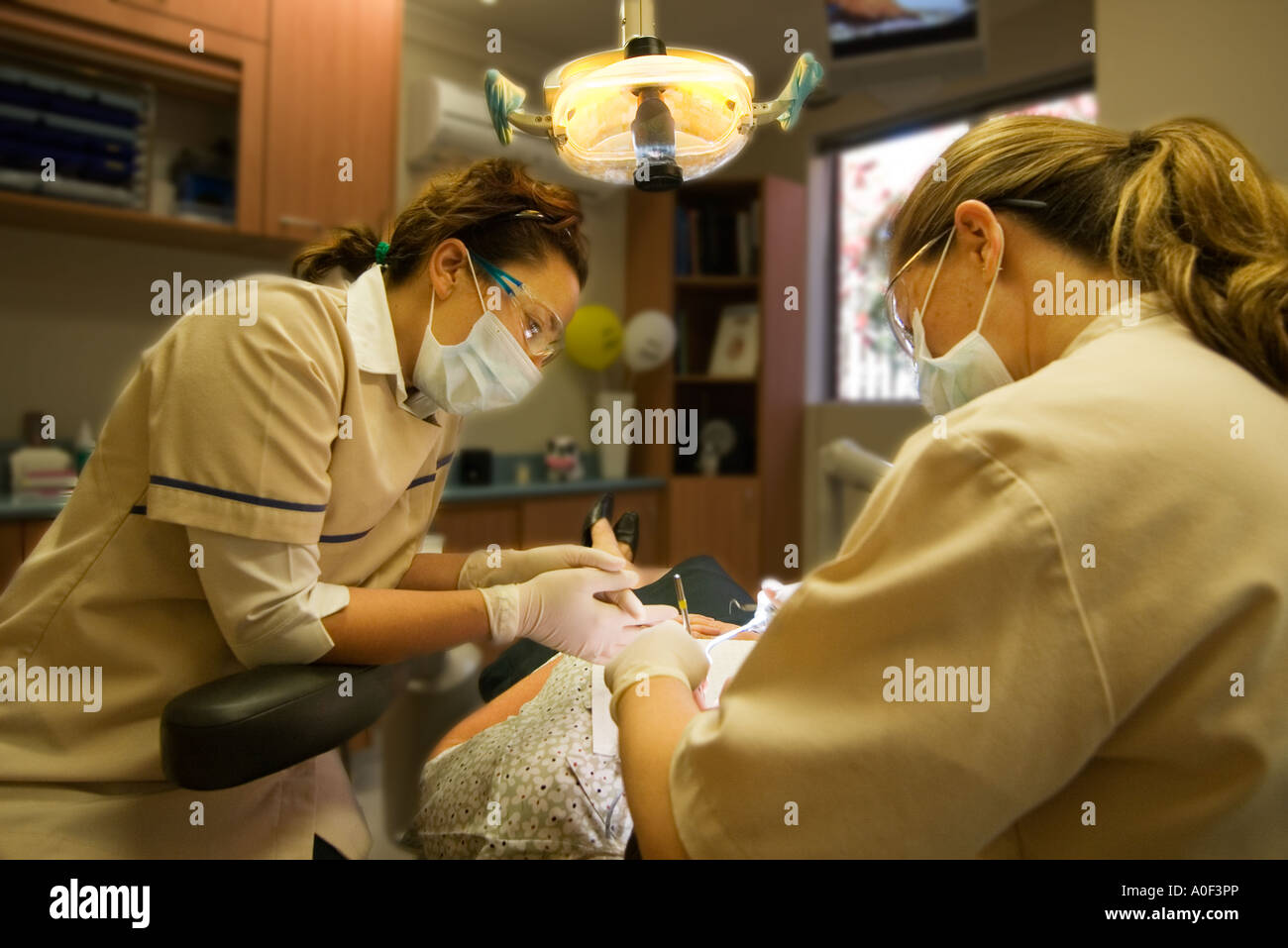 Dentist and dental nurse examining a patient in dentists surgery Stock ...