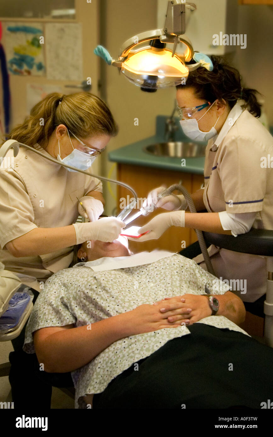 Dentist and dental nurse examining a patient in dentists surgery Stock ...