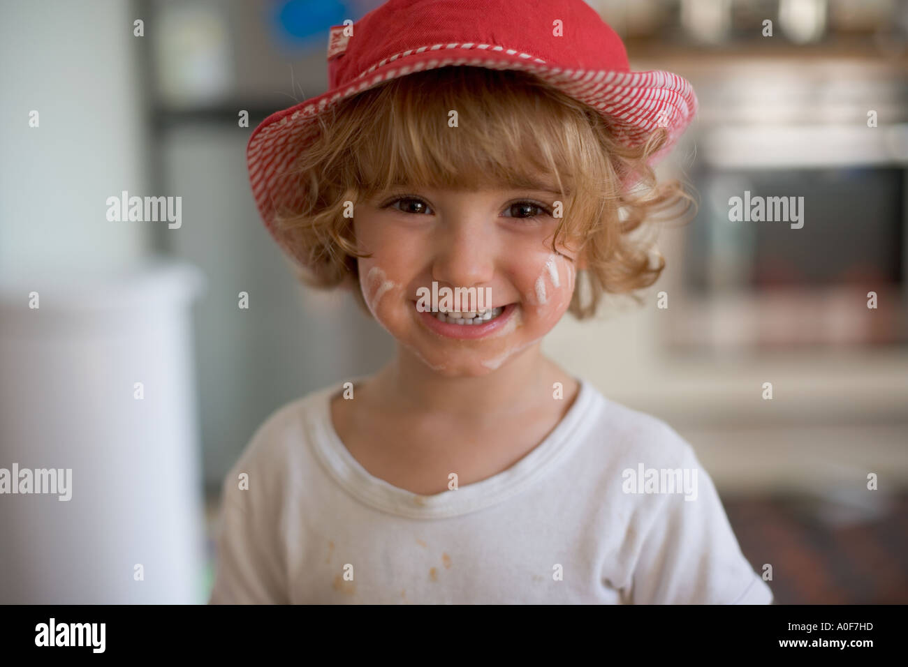 Young girl with mucky face and red hat smiling Stock Photo - Alamy