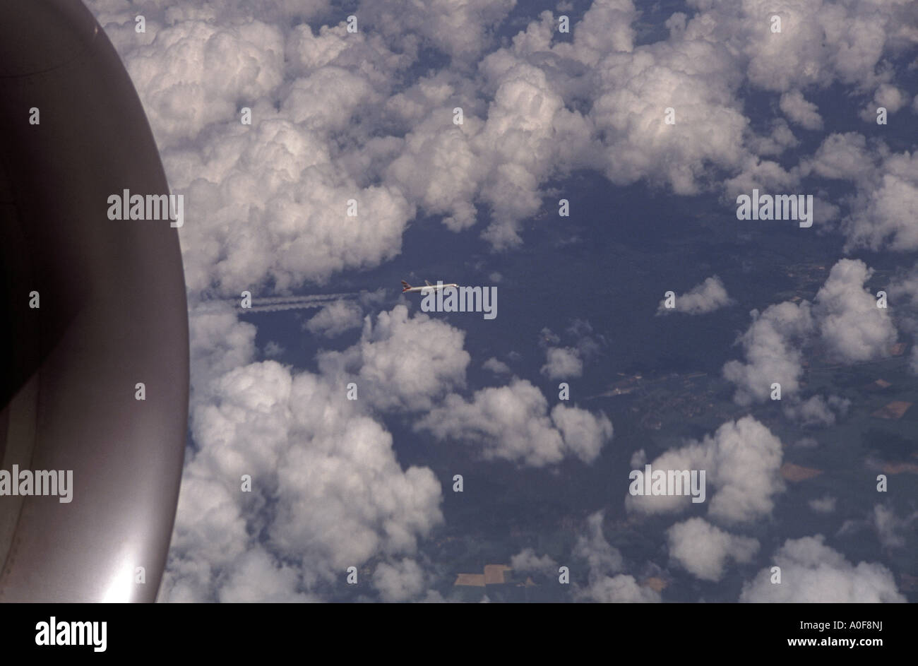 Plane seen in the distance from an aeroplane window travelling over ...