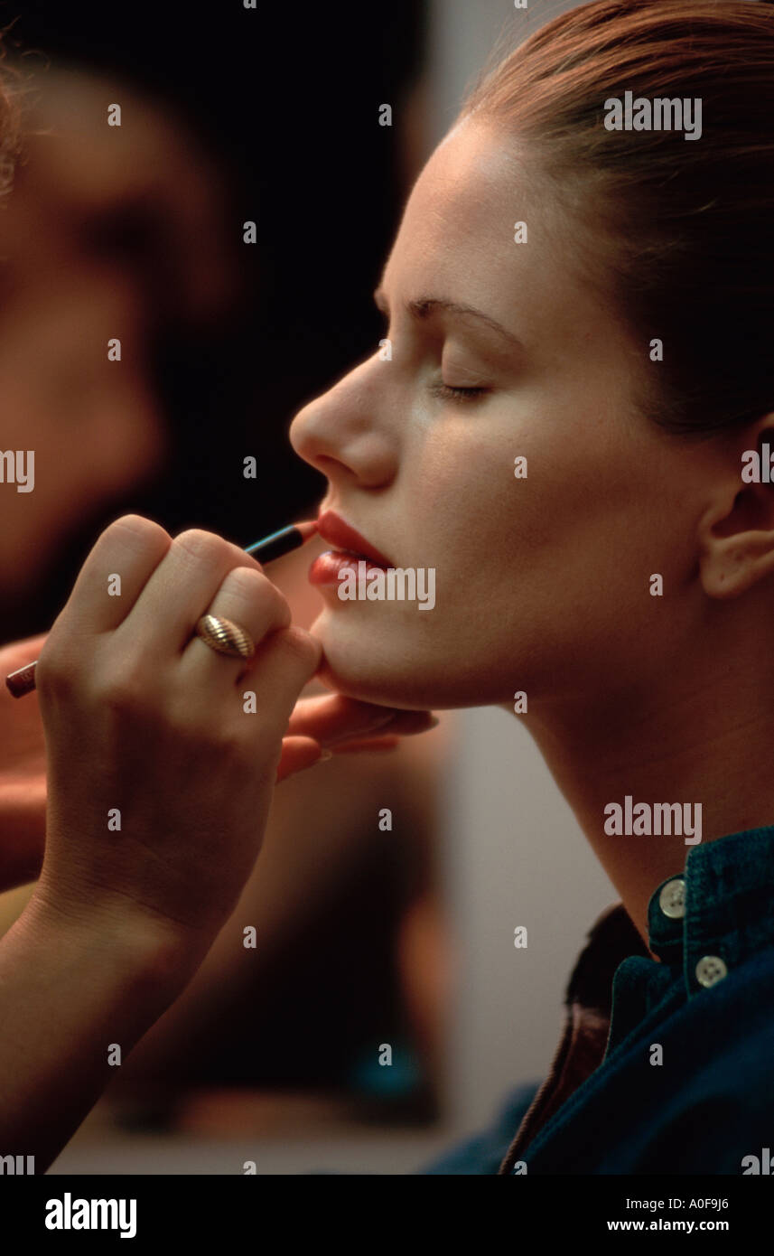 Side profile of a young woman applying lip liner Stock Photo - Alamy