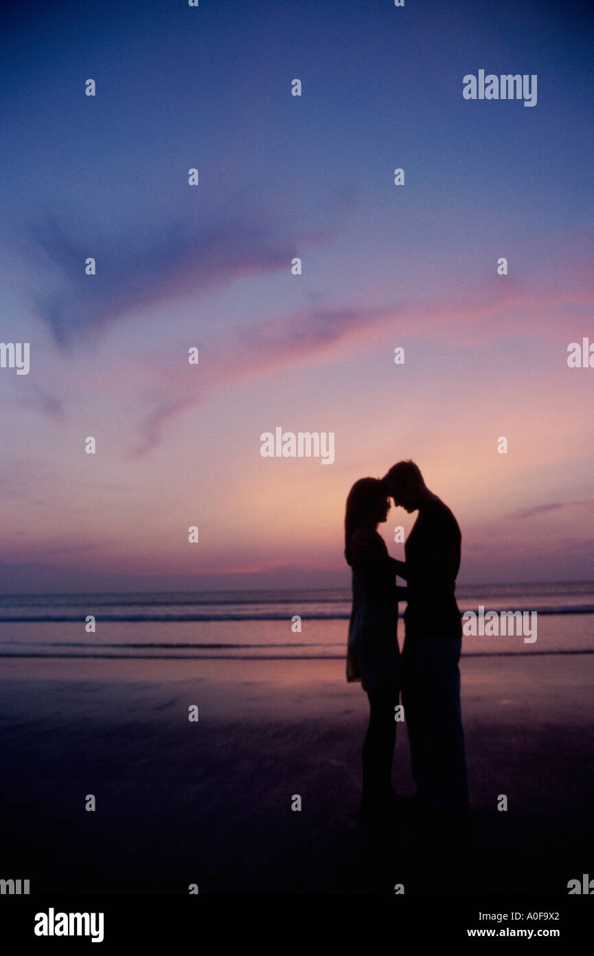 Silhouette of a young couple standing on the beach Stock Photo - Alamy