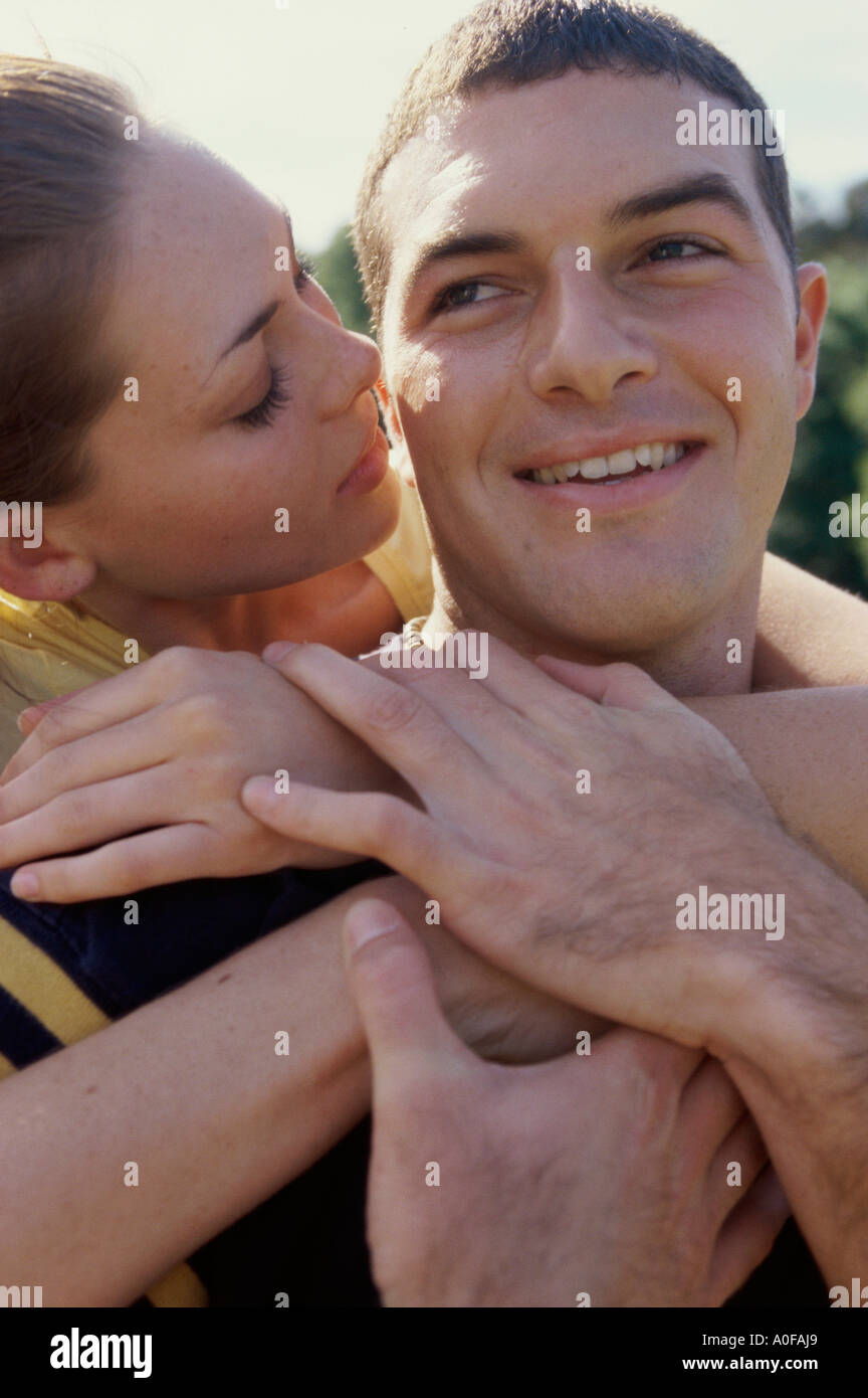 Young woman standing behind a young man with her arms around him Stock ...