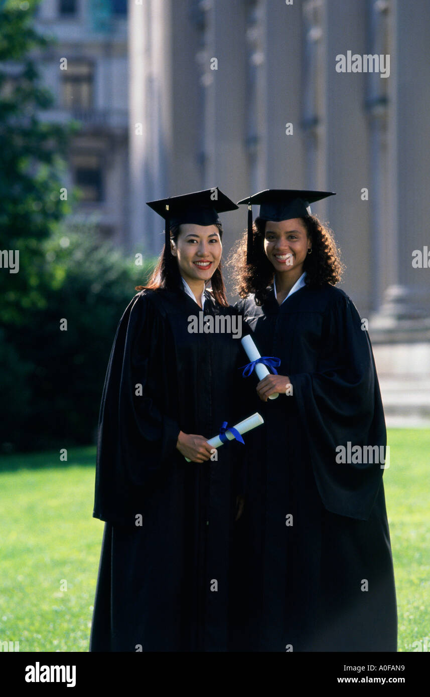 Two female graduates holding diplomas Stock Photo - Alamy