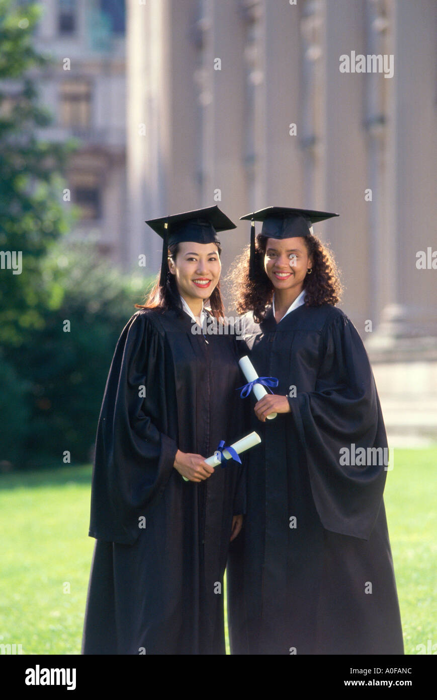 Two female graduates holding diplomas Stock Photo - Alamy