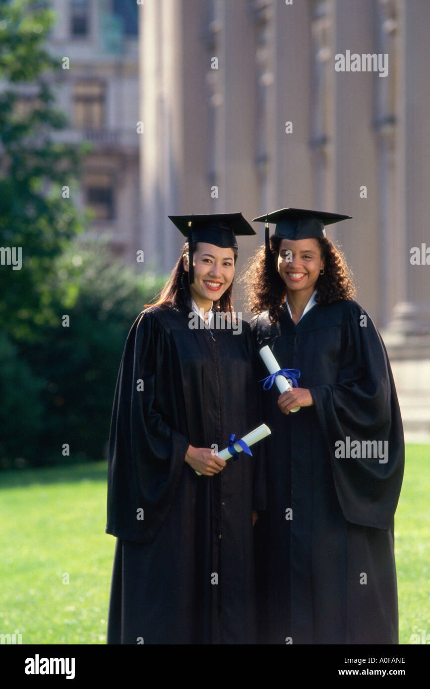 Two female graduates holding diplomas Stock Photo - Alamy