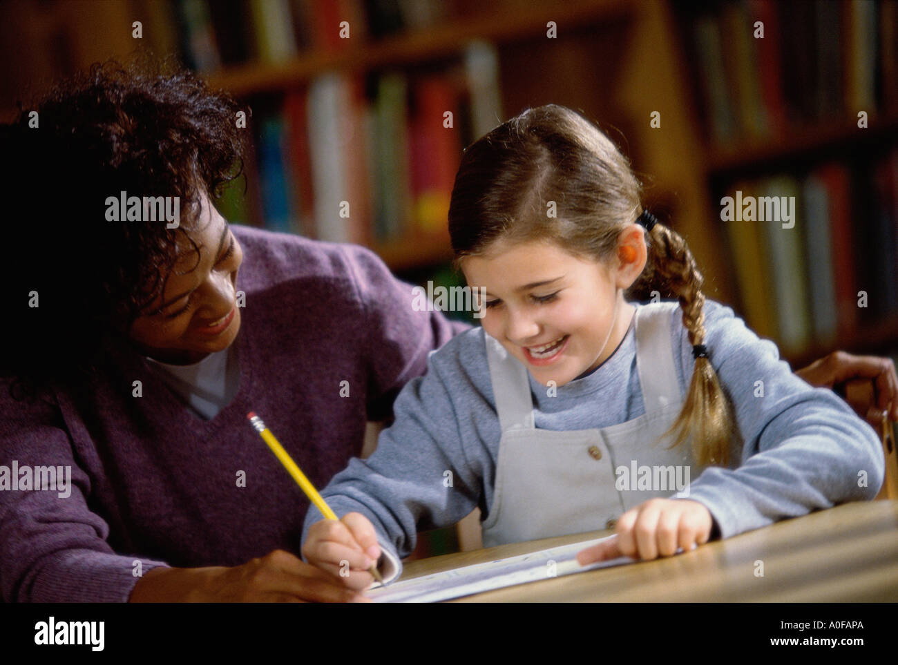 Female teacher teaching a girl Stock Photo - Alamy